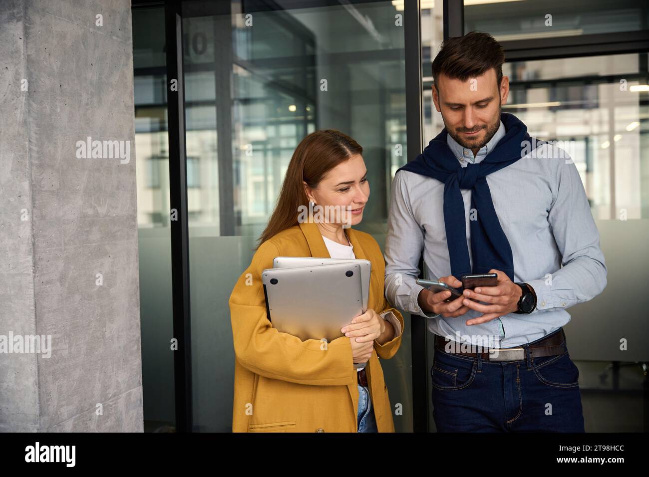 Colleagues communicate in the office corridor Stock Photo - Alamy