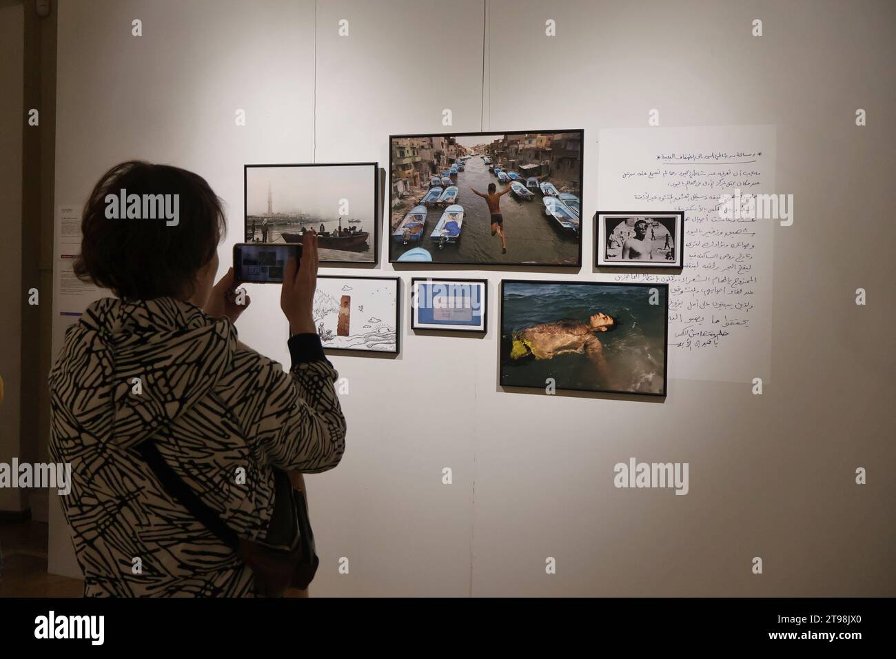 A woman takes photographs on the wall of participants in the World ...