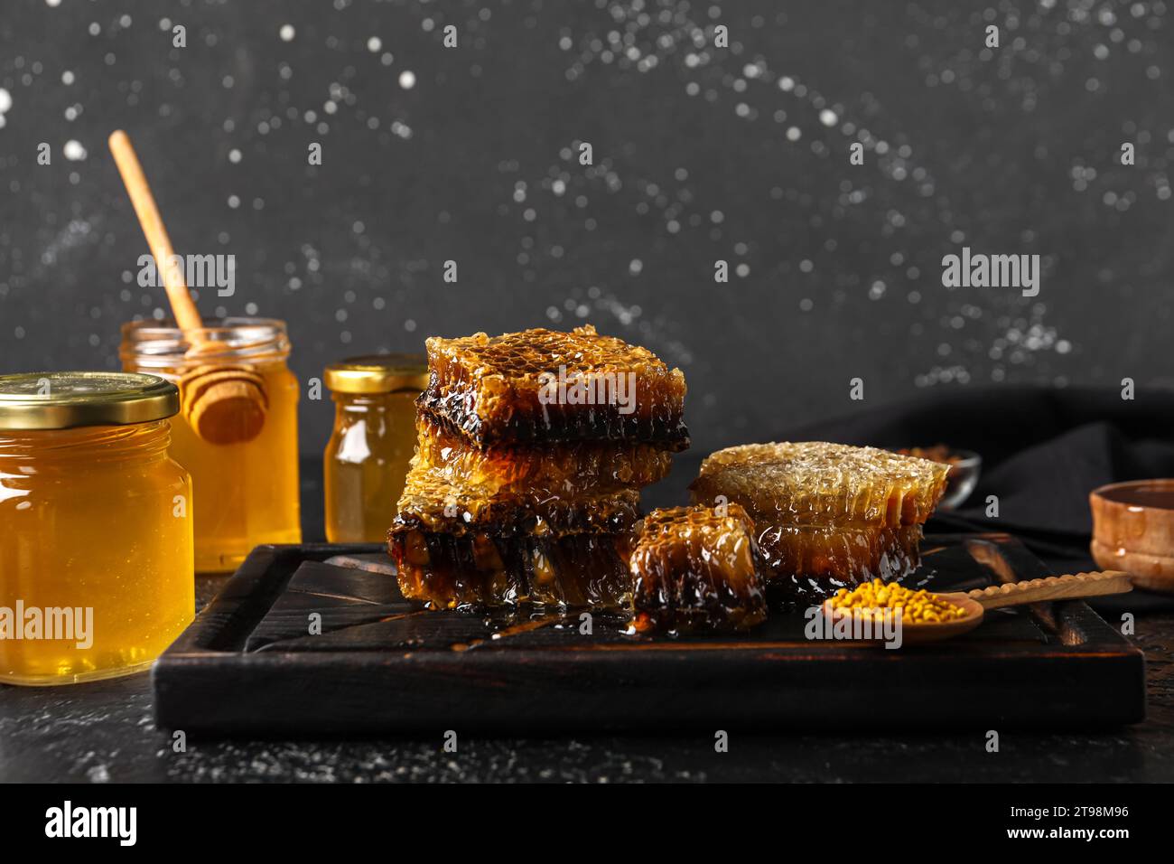 Sweet honey, combs and bee pollen on black background Stock Photo - Alamy