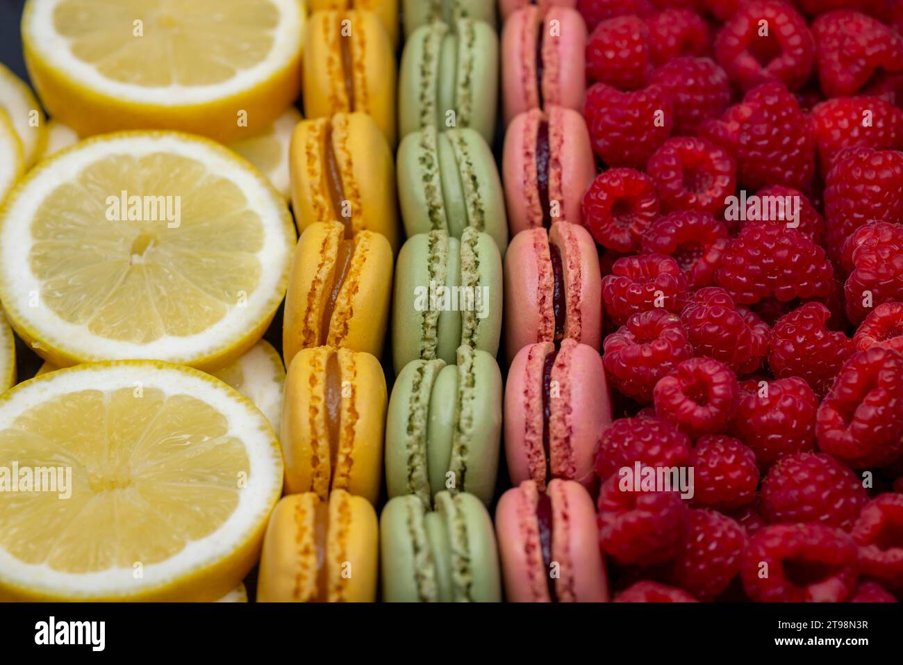 macaroons of different colors with raspberries and lemon Stock Photo ...