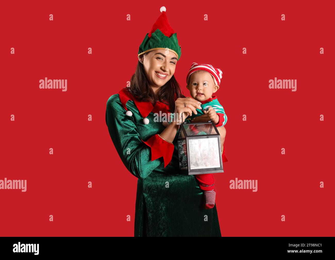 Young mother and cute little baby dressed as elves with Christmas ...