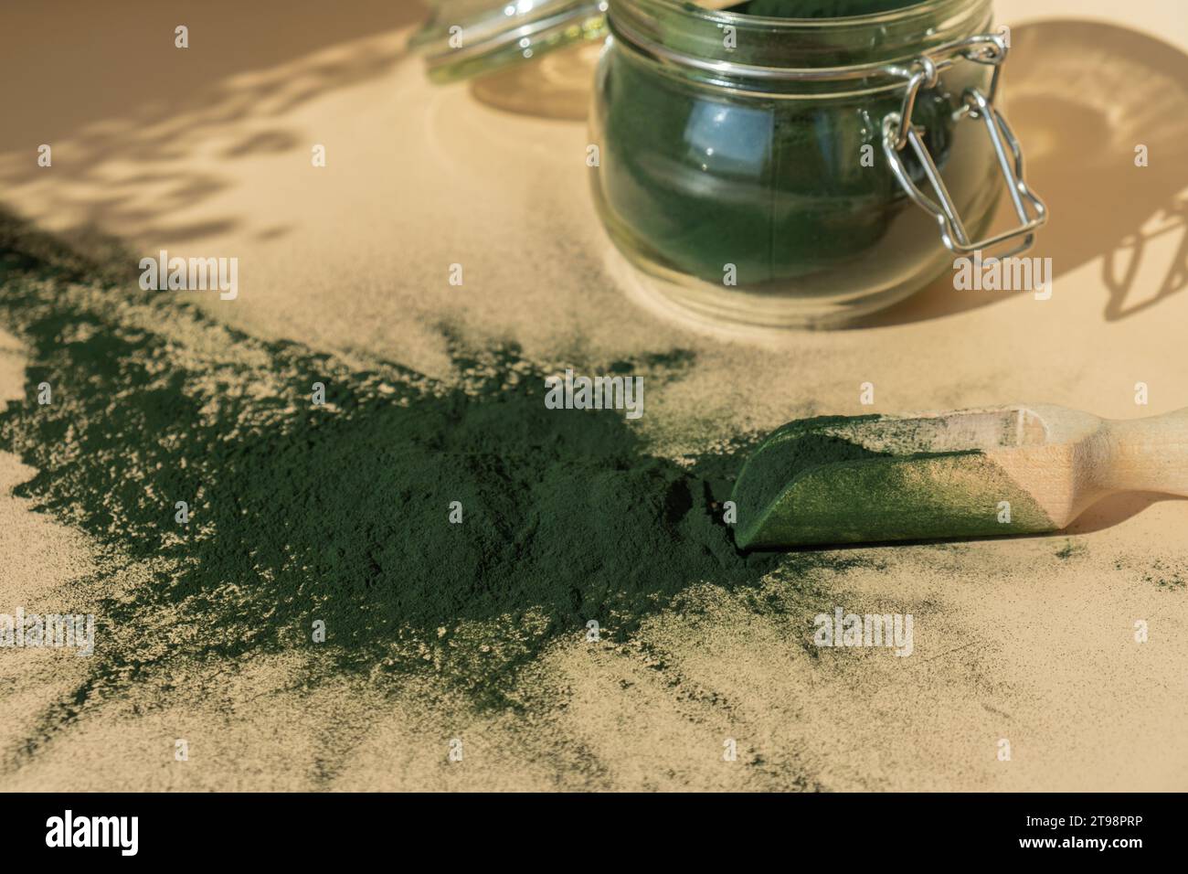 Organic blue-green algae spirulina powder food in glass jar with wooden ...