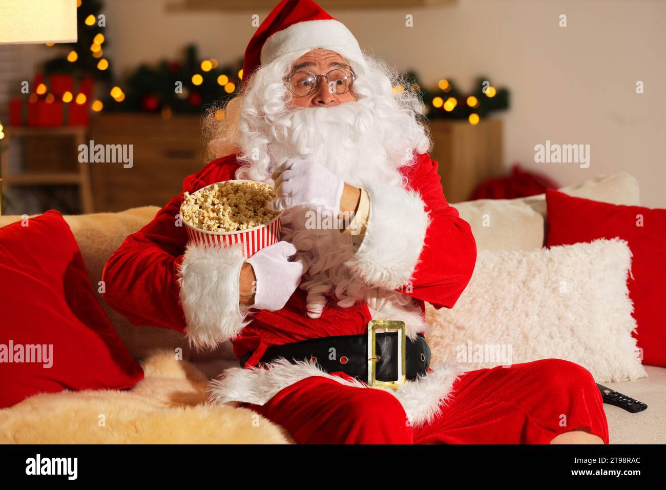 Merry Christmas. Emotional Santa Claus with popcorn bucket watching TV ...