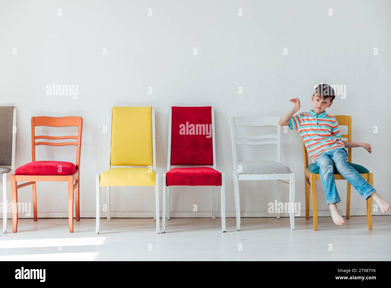 boy and many different chairs in the interior of a white room Stock ...