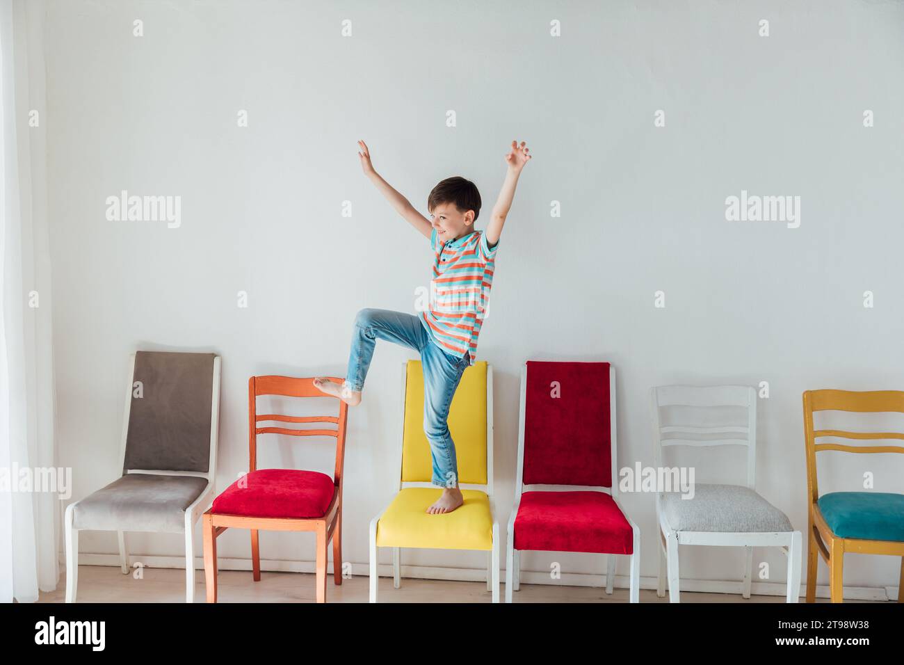 boy and many different chairs in the interior of a white room Stock ...
