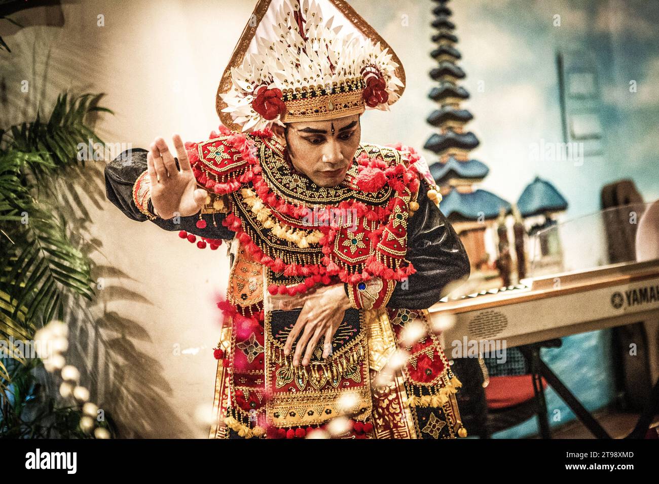 A male Balinese dancer is dancing a traditional Balinese dance wearing ...