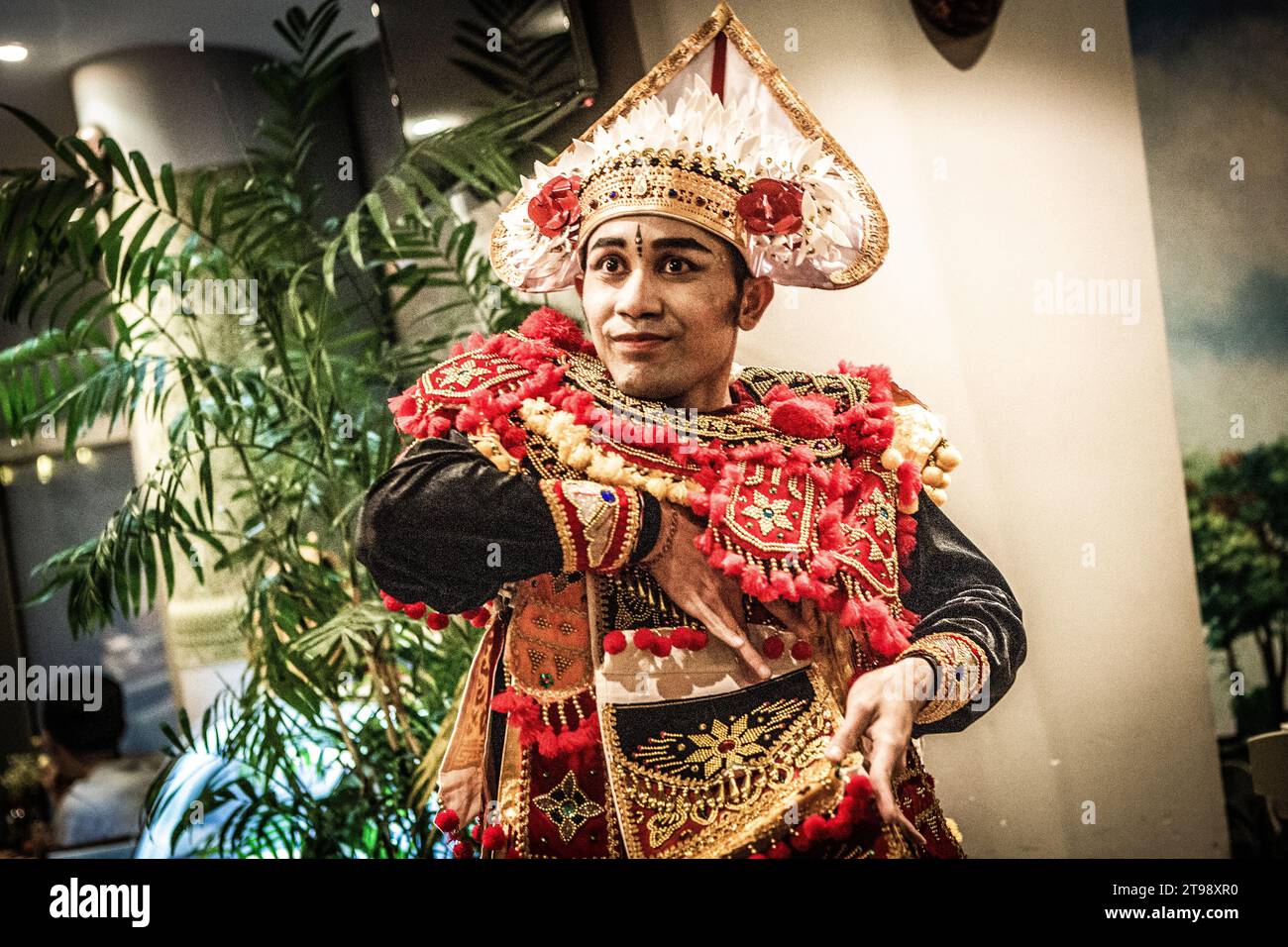 A male Balinese dancer is dancing a traditional Balinese dance wearing ...