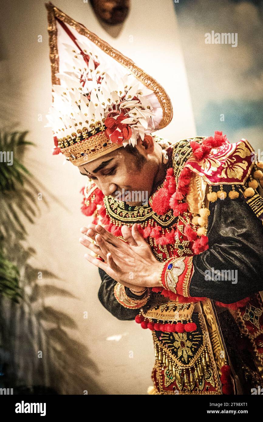 A male Balinese dancer is dancing a traditional Balinese dance wearing ...