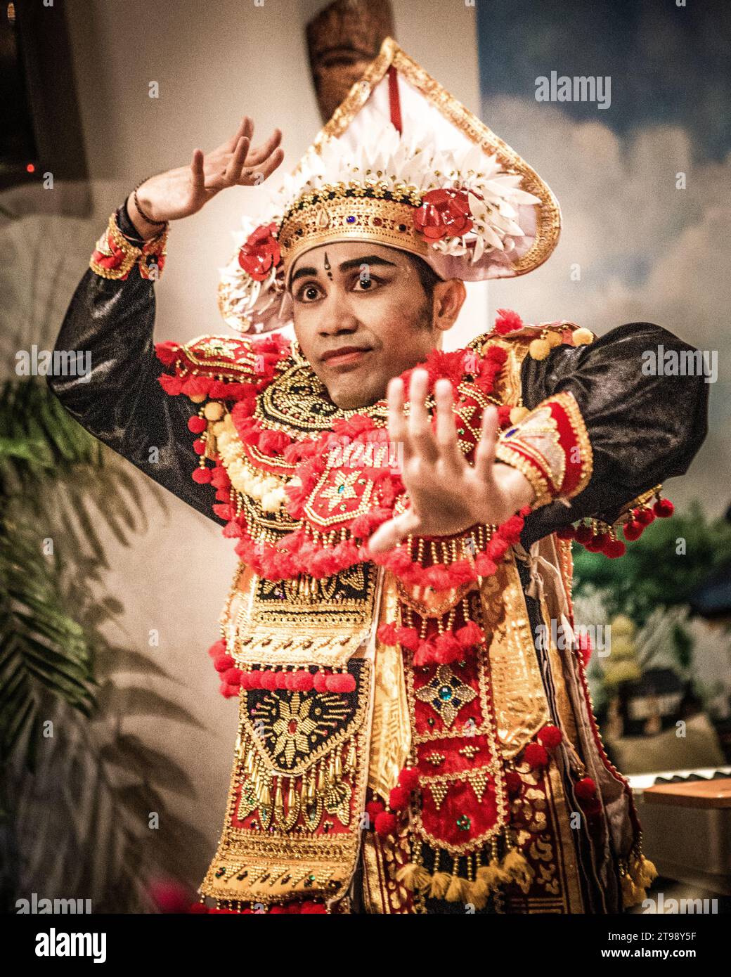 A male Balinese dancer is dancing a traditional Balinese dance wearing ...