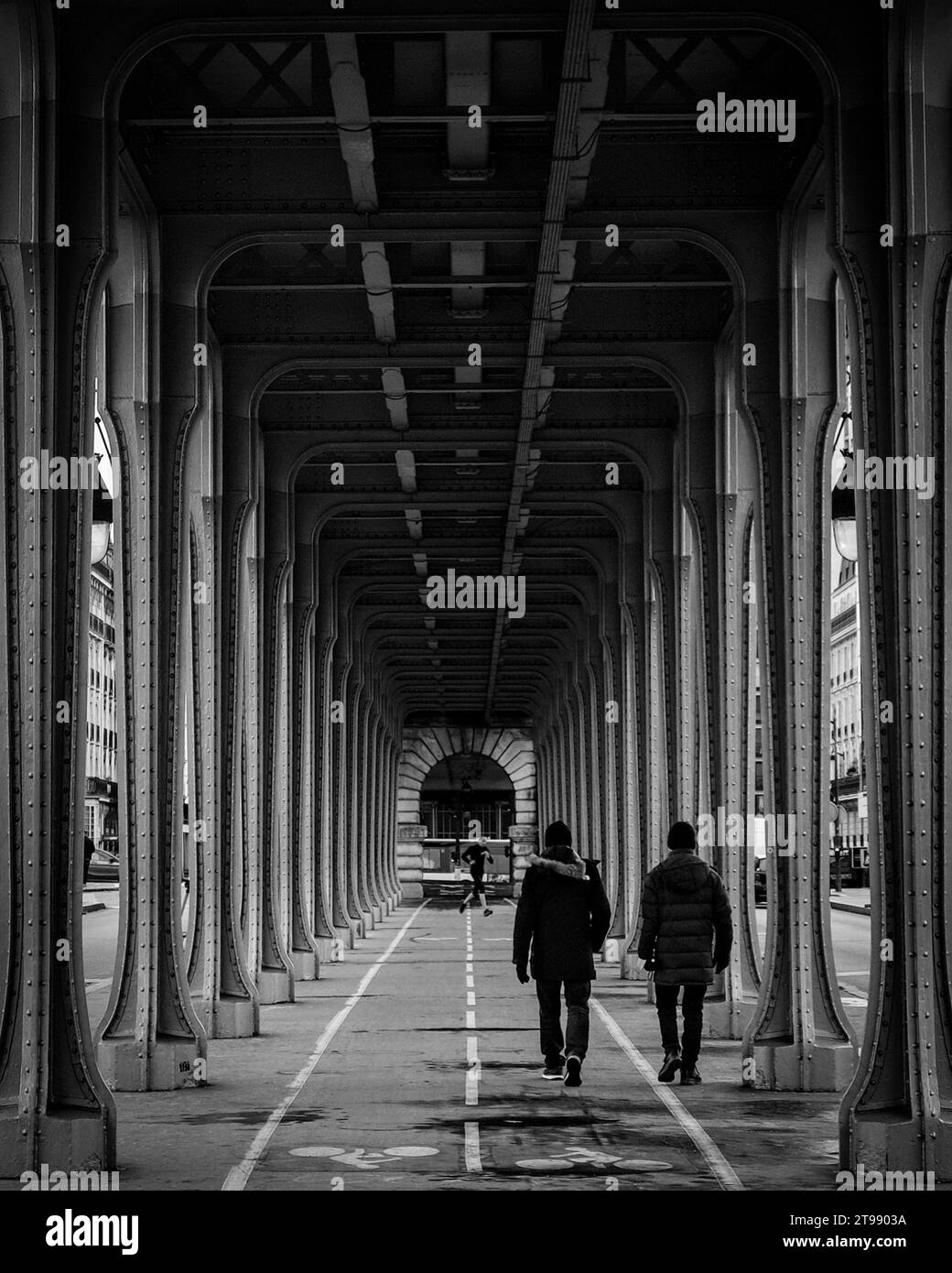Two people strolling side by side through an open air covered walkway ...