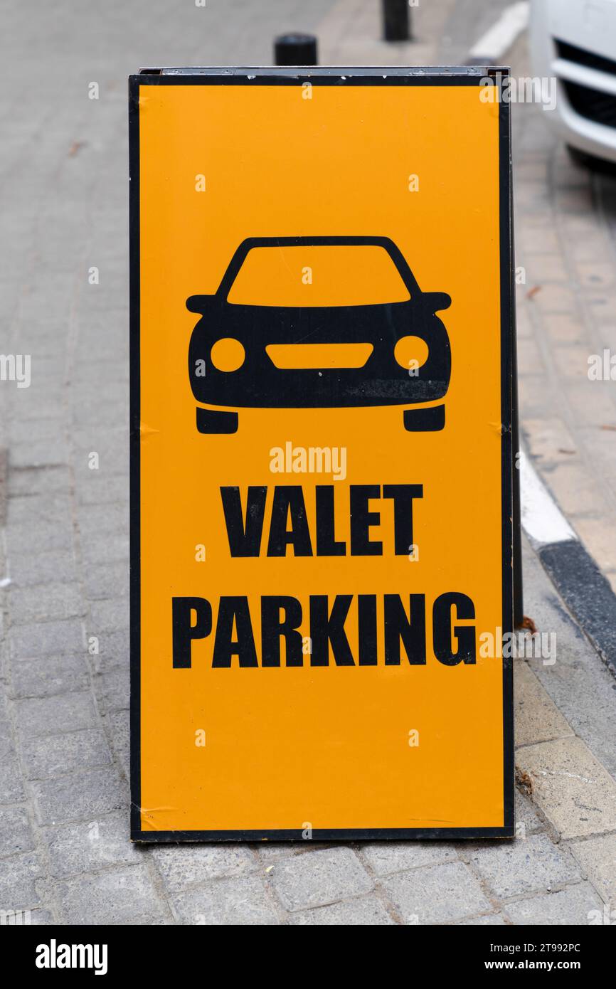 Orange color sign for valet parking in the street Stock Photo - Alamy