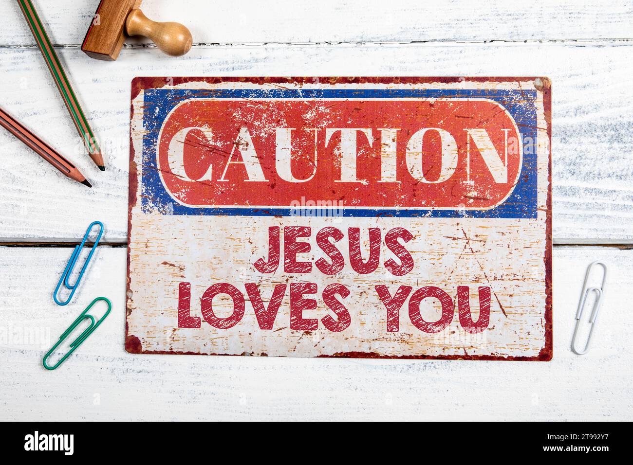 Jesus Loves You. Metal CAOTION plate with text on a white wooden ...