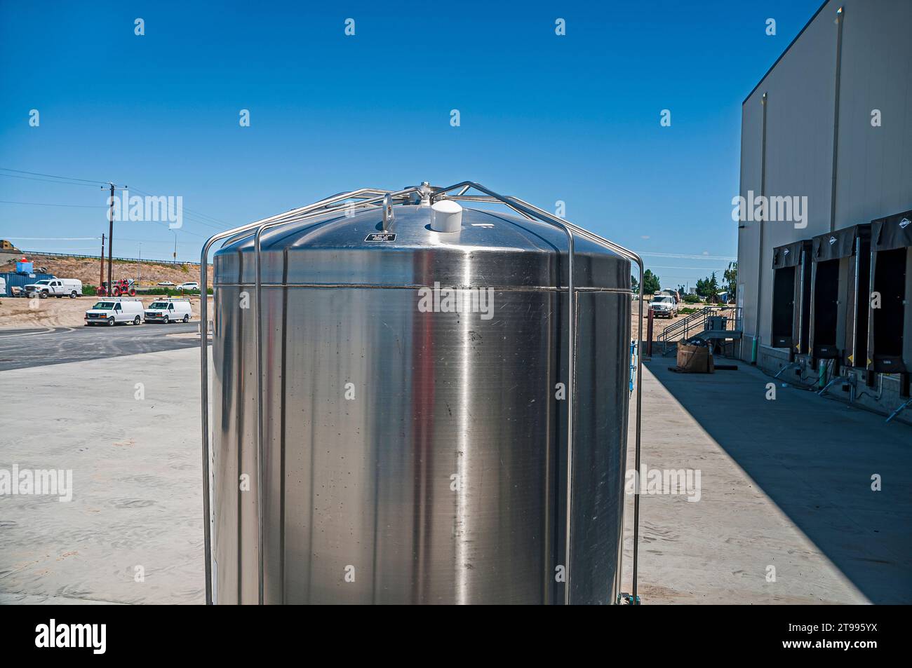 The top of a stainless-steel tank, outdoors on a metal pallet at an CO2 ...