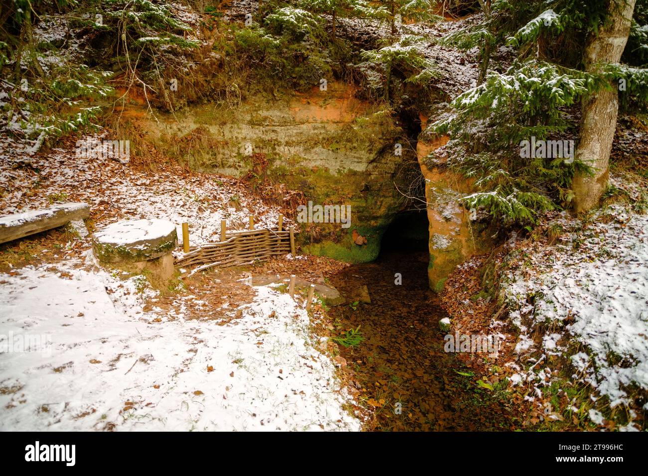 The water flows from a small cave opening, forming a natural spring ...