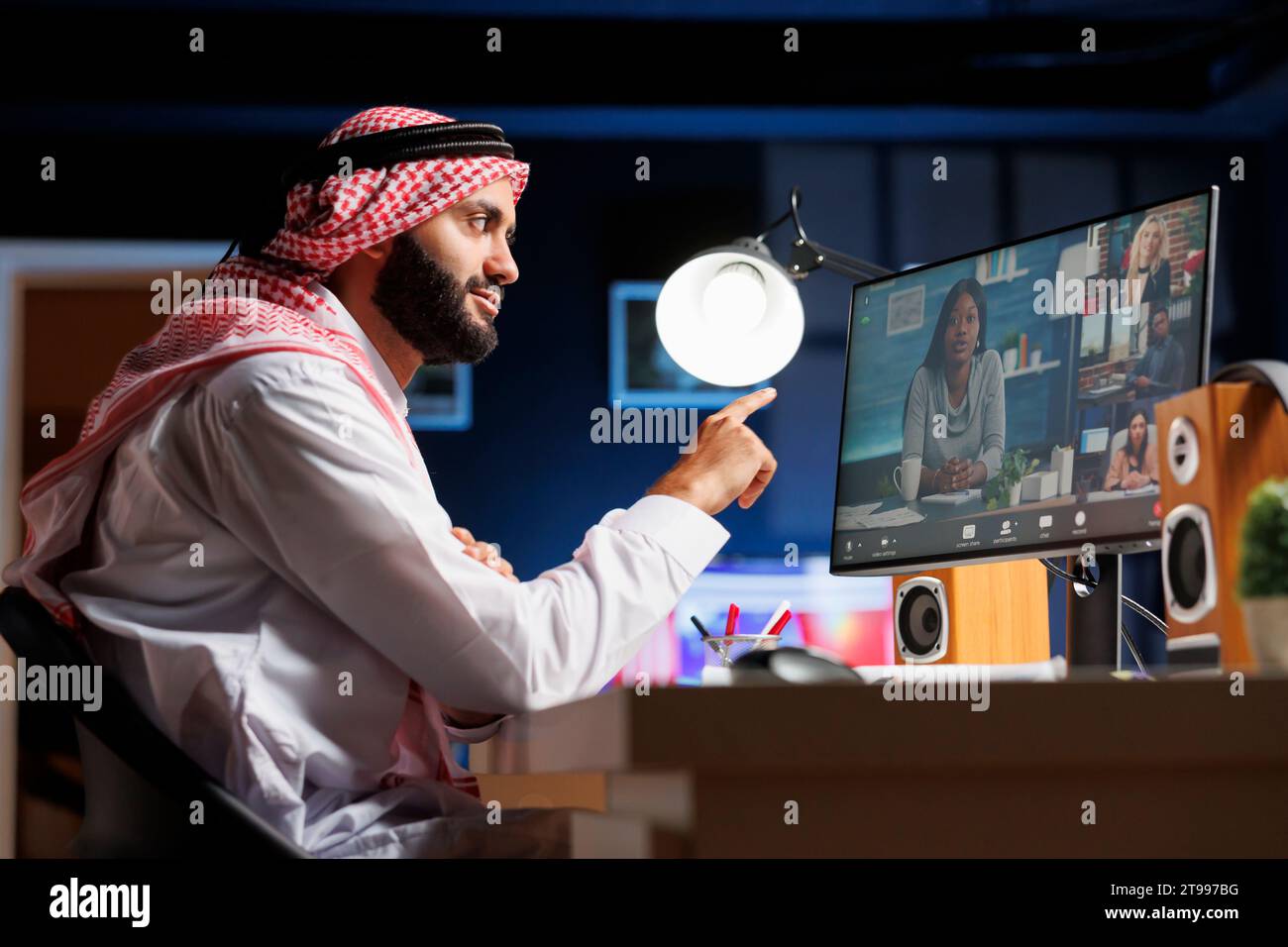 On computer, Muslim guy is carefully listening to his coworkers during ...