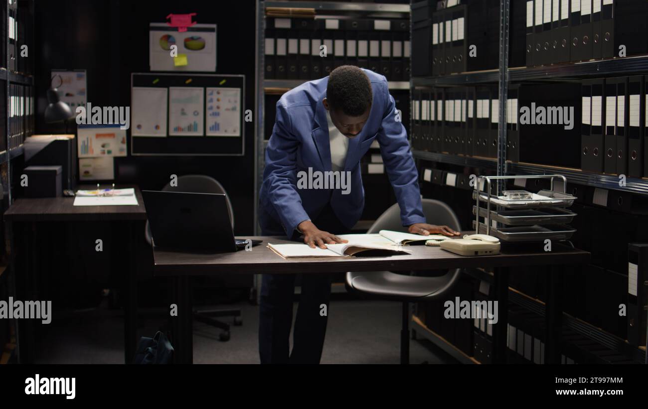 African american private investigator standing and cross-checking clues ...