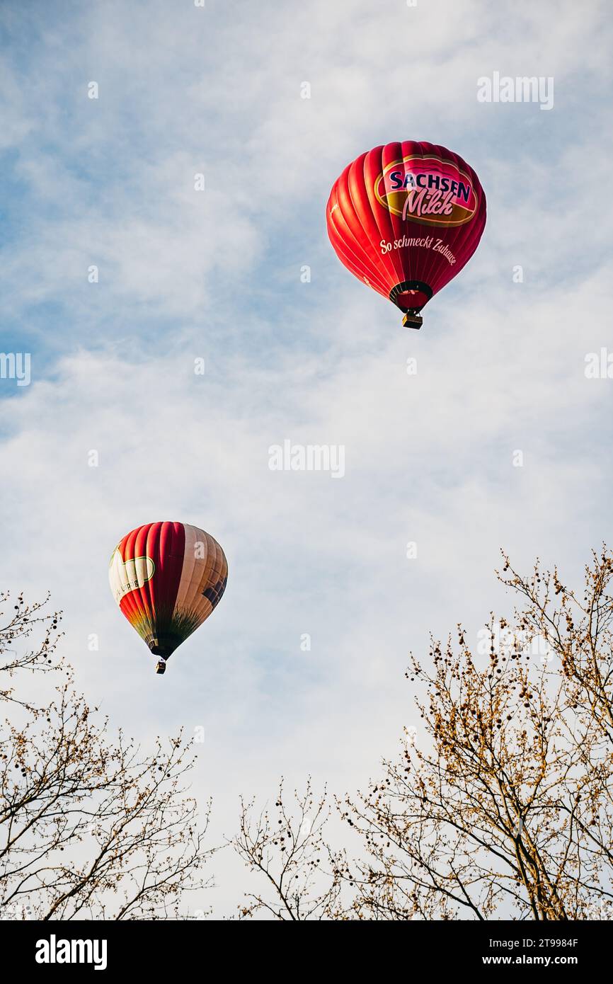 Two vibrant hot air balloons floating peacefully in the sky amongst a ...