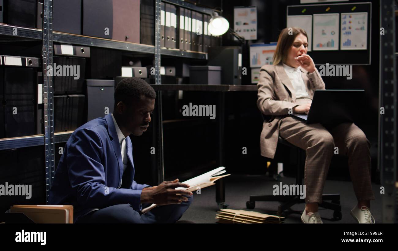 African american detective and policewoman with laptop examine evidence ...