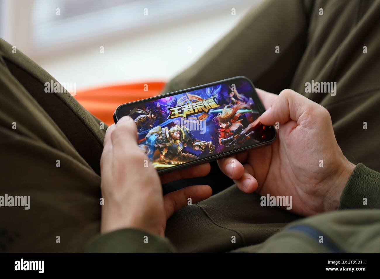 Honor of Kings mobile iOS game on iPhone 15 smartphone screen in male ...