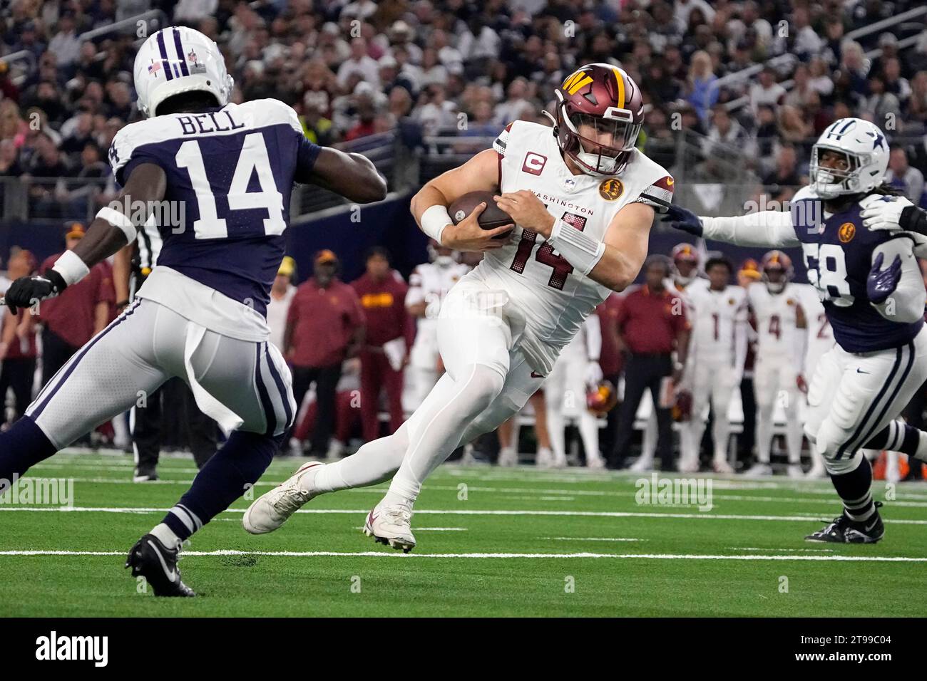 Washington Commanders quarterback Sam Howell, middle, runs for a ...