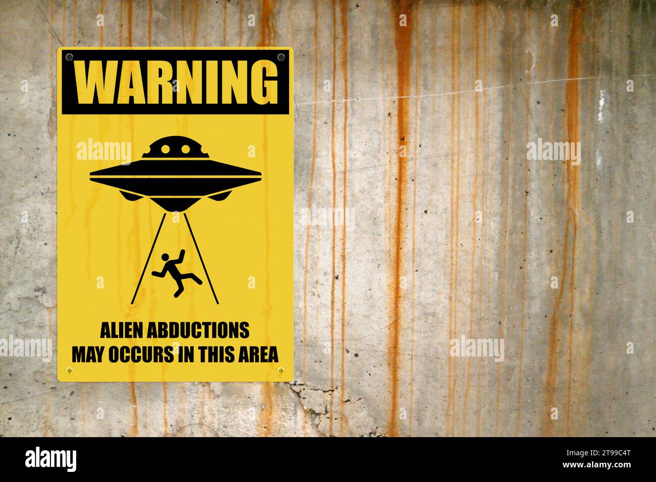 Yellow and black warning sign screwed to a concrete wall to warn about ...