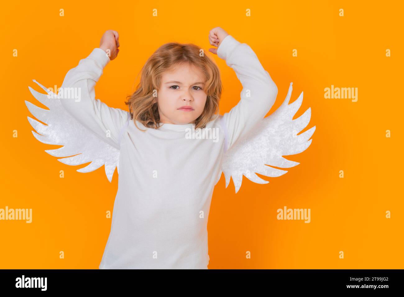 Child angel. Portrait of cute kid with angel wings isolated on yellow ...