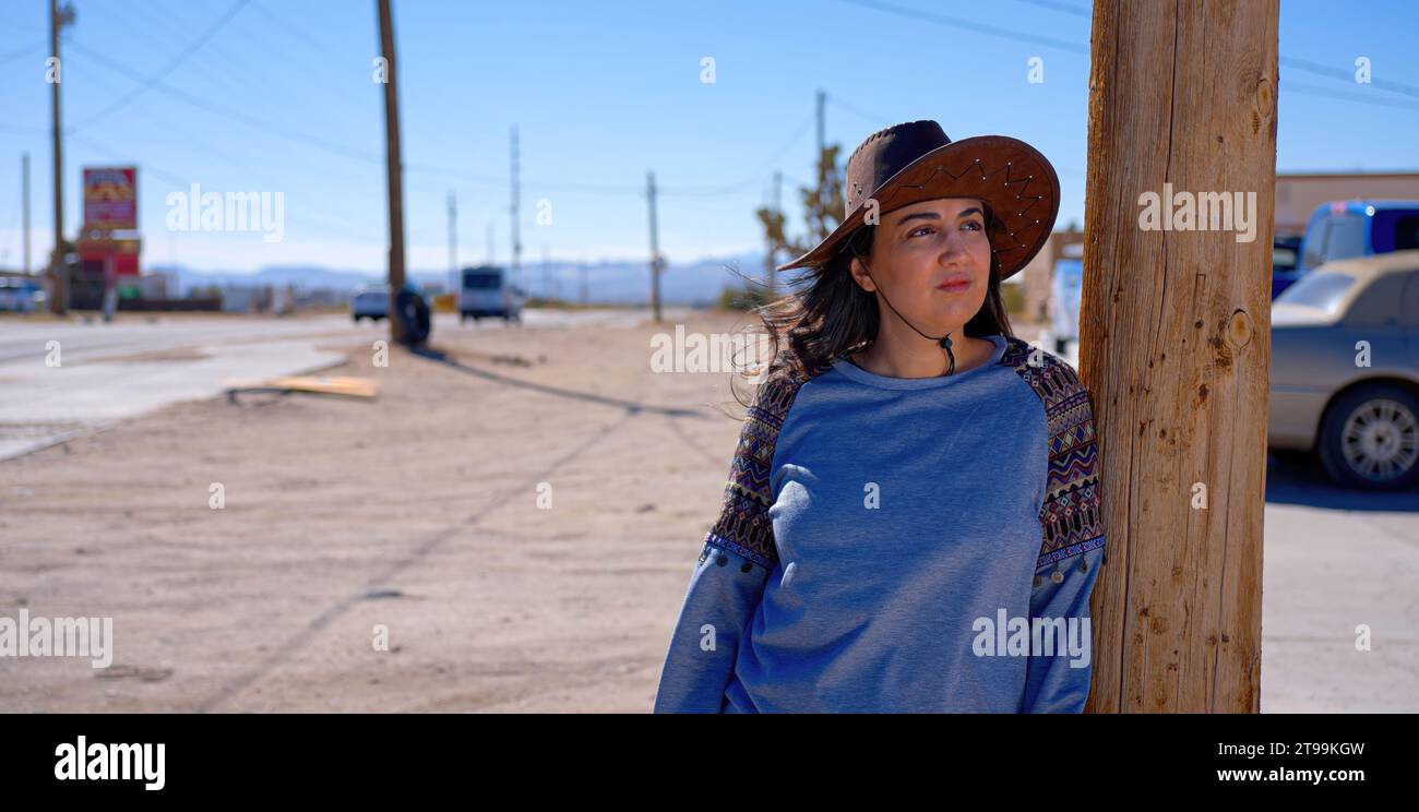 Cowgirl leaning against a pole in the village of Dolan Springs Arizona ...
