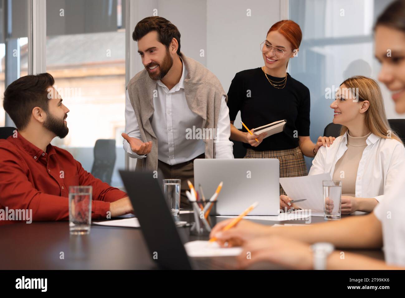Team of employees working together in office Stock Photo - Alamy