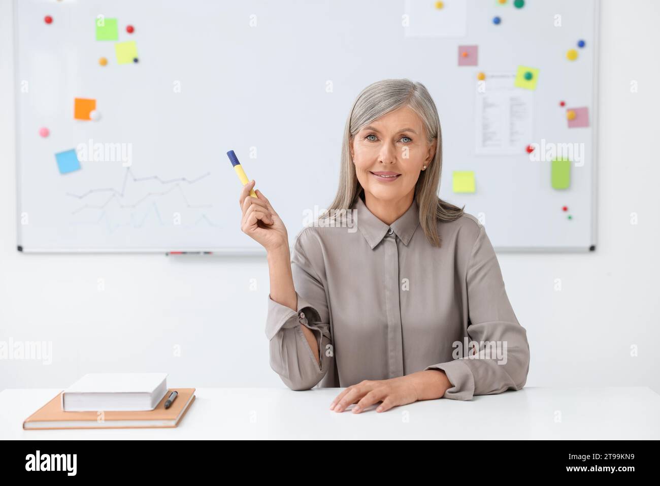 Happy professor giving lecture at desk in classroom, space for text ...