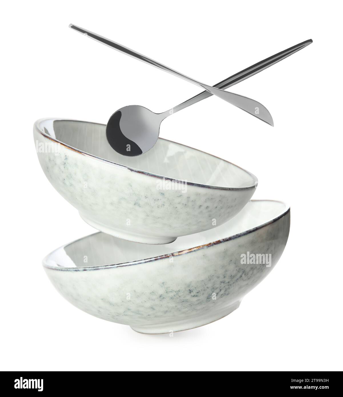 Clean dishes, spoon and knife falling on white background Stock Photo ...