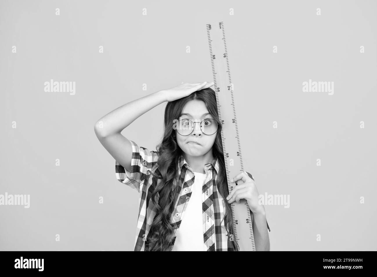 Kid height measure, growth measurement. Funny face. School girl holding ...