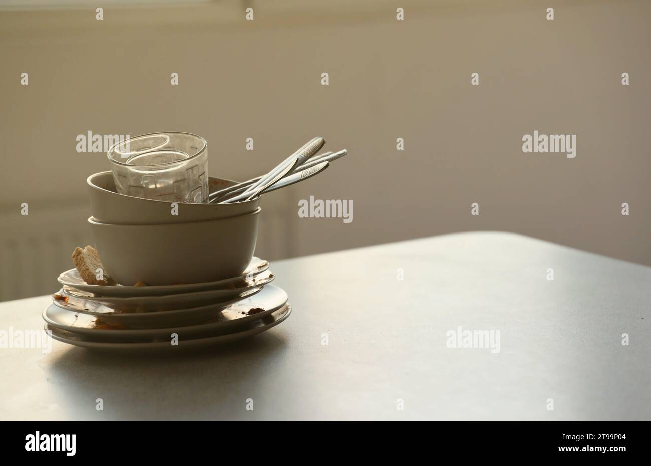 Stack of dirty dishes with food leftovers on the table after meal ...