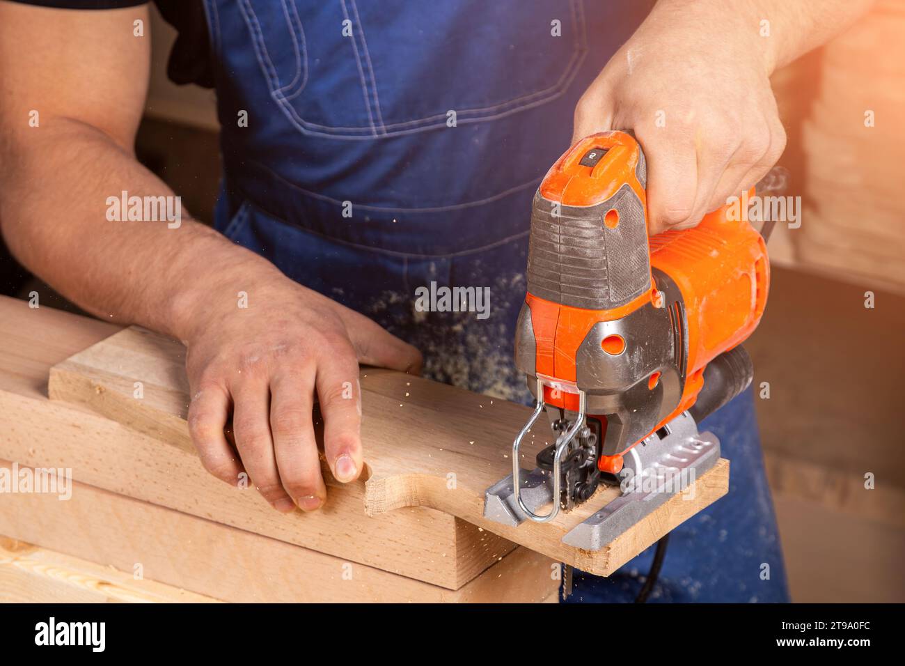 A carpenter using a jigsaw to cut wood cuts bars. Home repair concepts ...