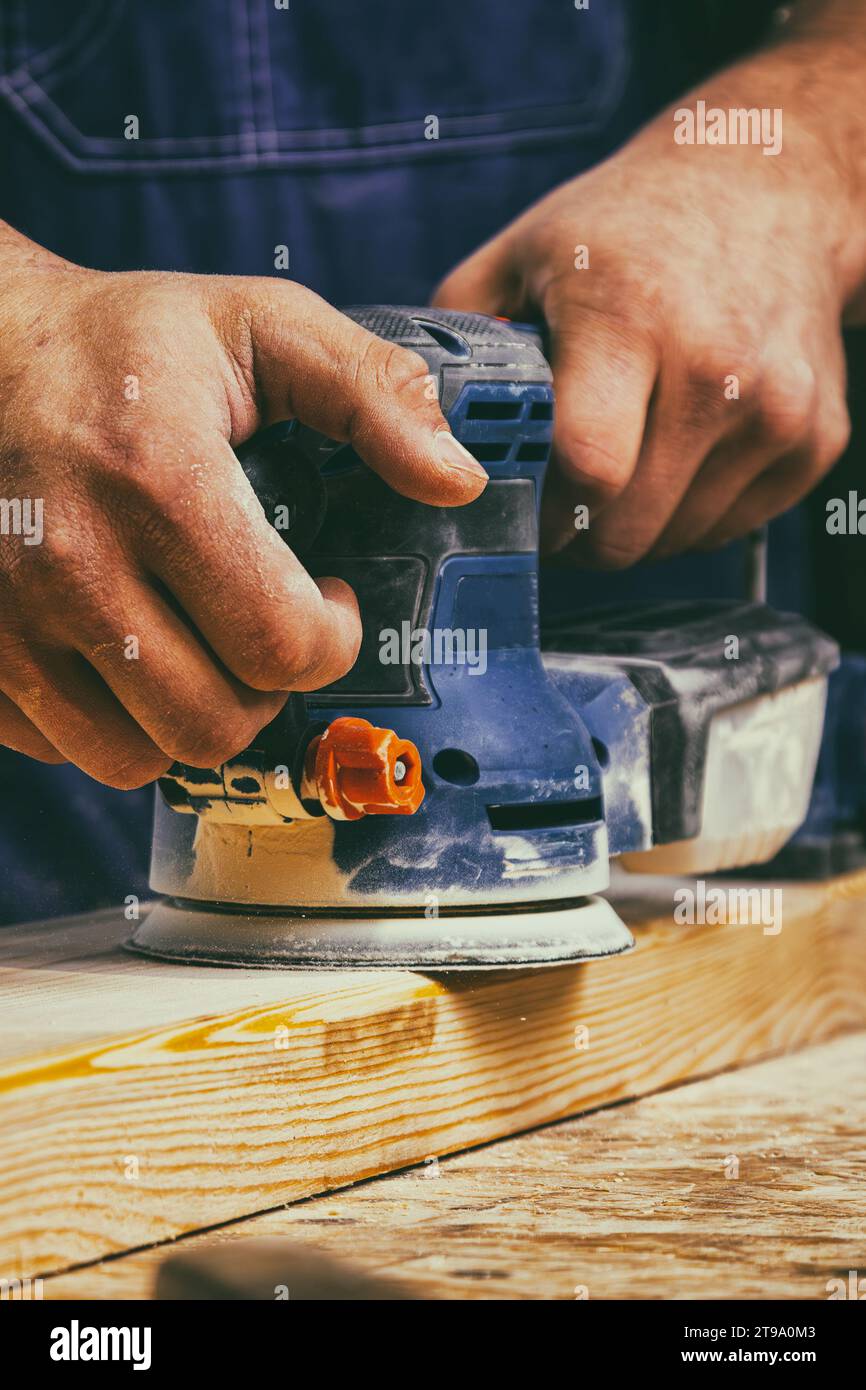 Worker grinds the wood of angular grinding machine Stock Photo - Alamy