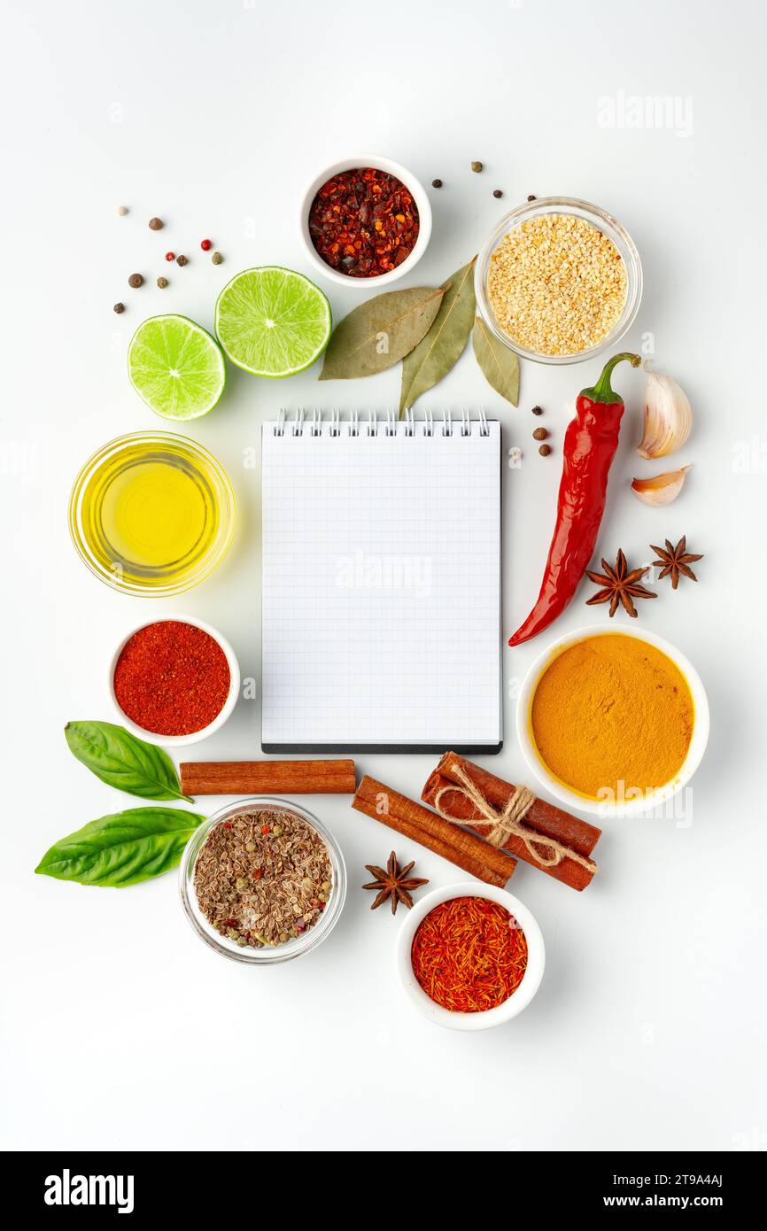 Blank notepad surrounded by different ingredients and spices on white ...