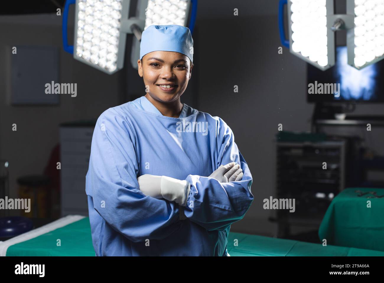 Portrait of happy biracial female surgeon wearing surgical gown in ...