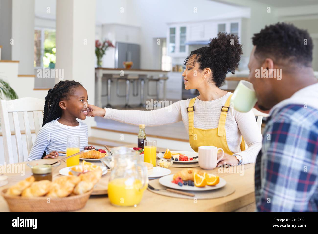 Happy african american family having fresh fruits snack in dining room at home, copy space ...