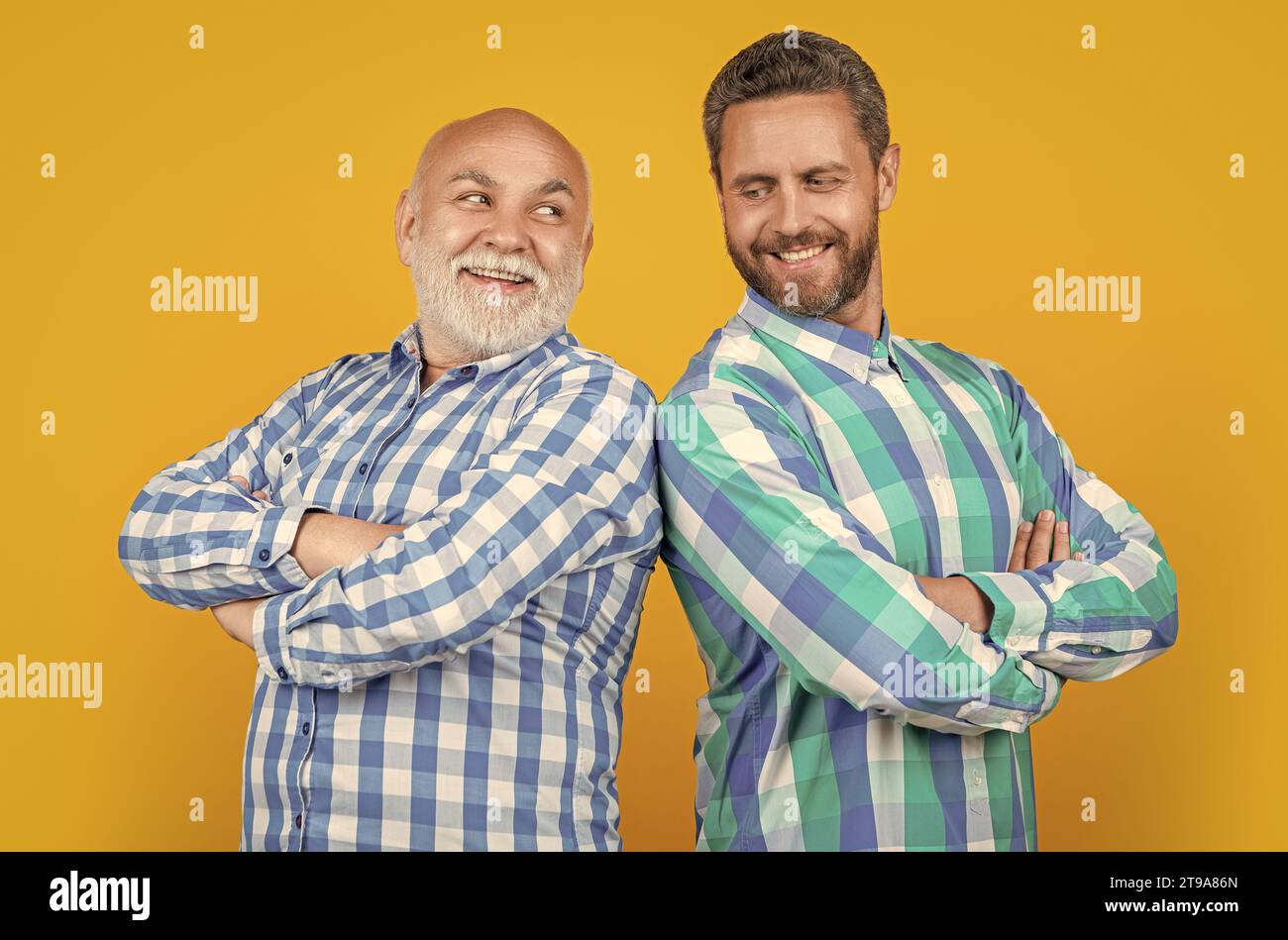 cheerful two generation family men isolated on yellow. two generation ...