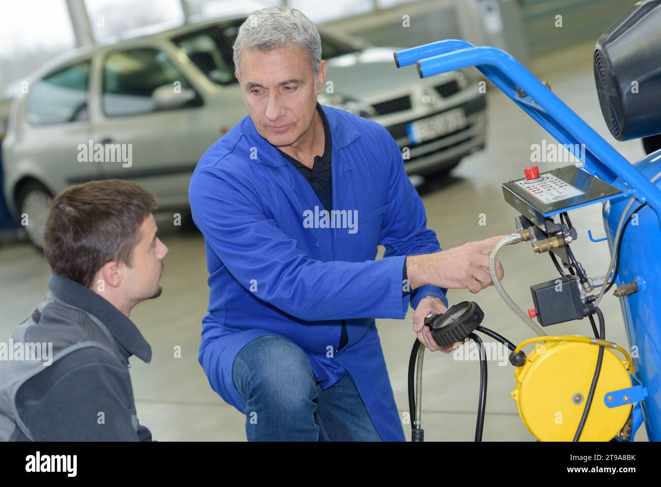 student with instructor repairing a car during apprenticeship Stock ...