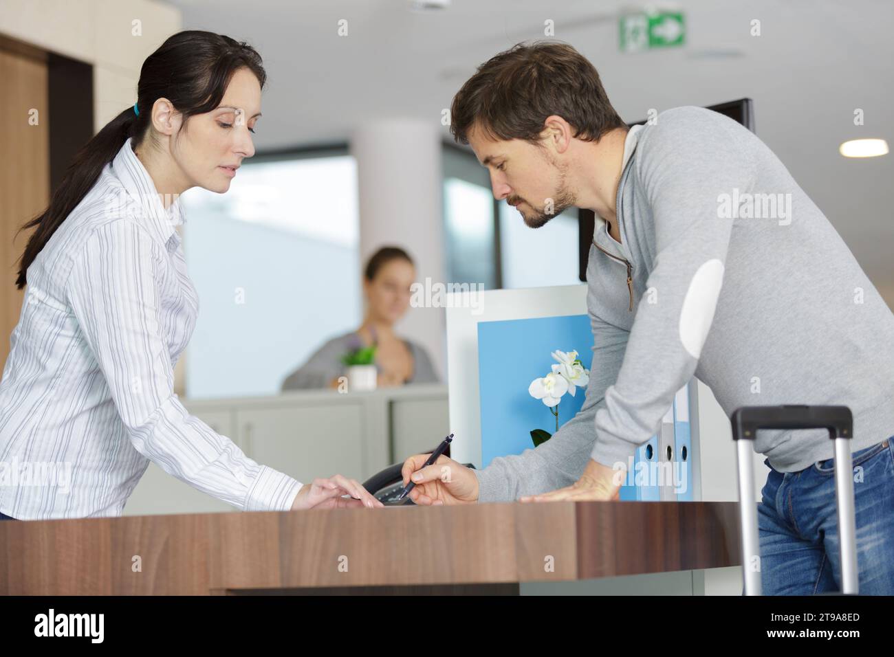 Patient talking receptionist hi-res stock photography and images - Alamy