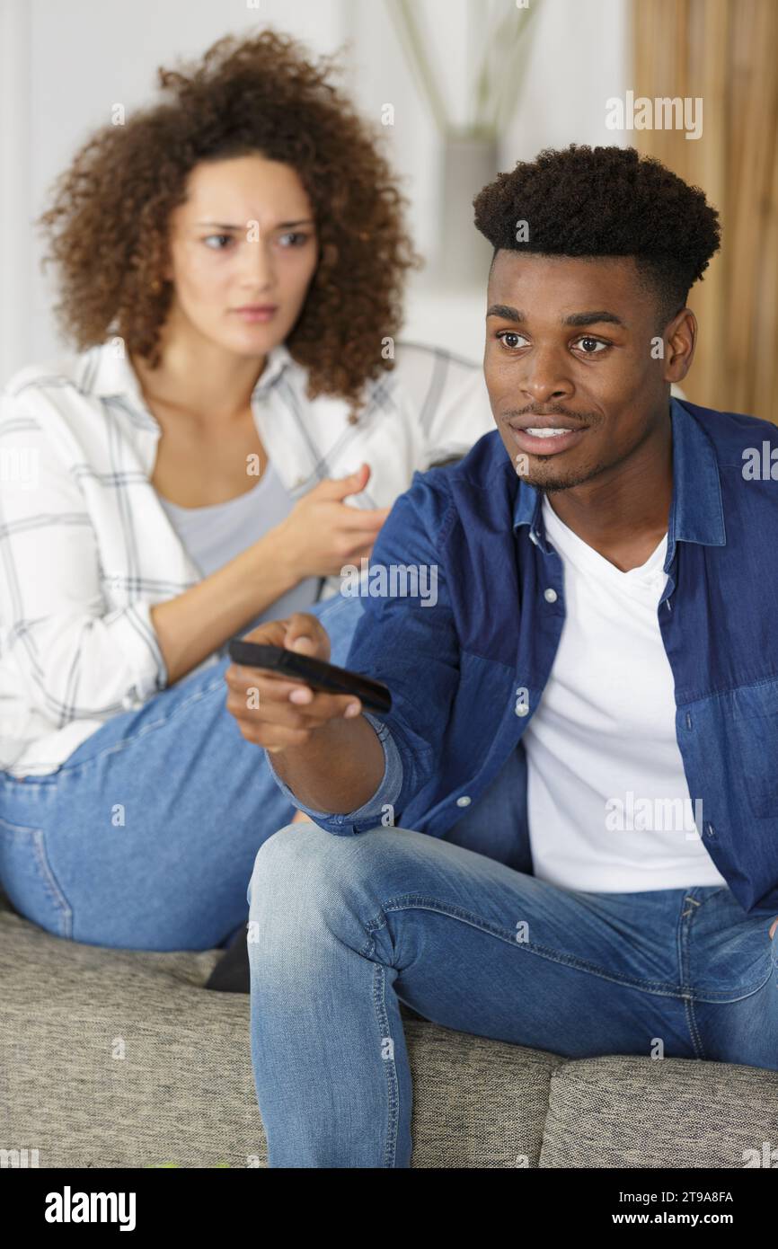incredulous girlfriend resenting boyfriend with remote control Stock ...