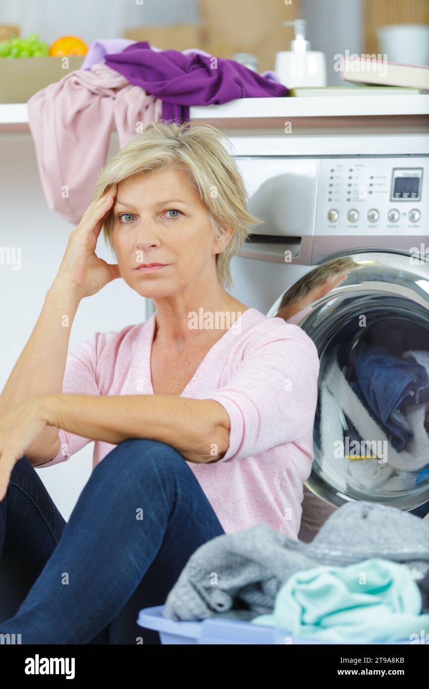 Woman loading washing machine tired hi-res stock photography and images ...