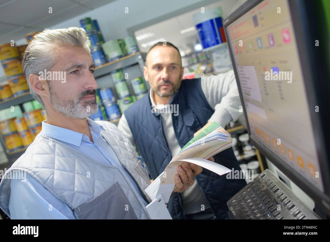 warehouse workers looking at pc Stock Photo - Alamy