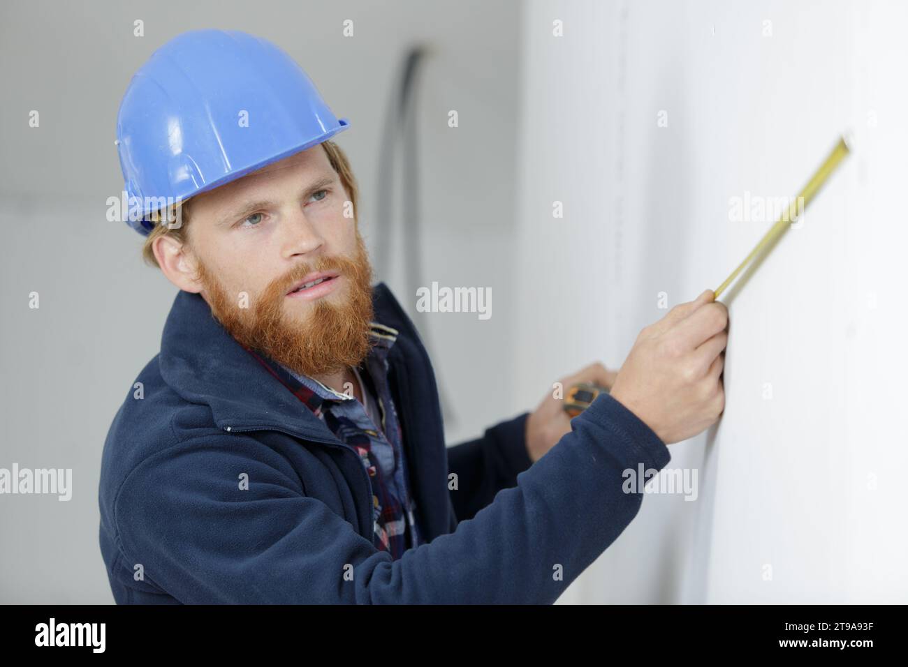 man measuring a wall using a ruler Stock Photo - Alamy