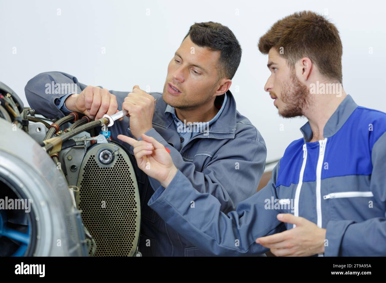 two men working on engine Stock Photo - Alamy