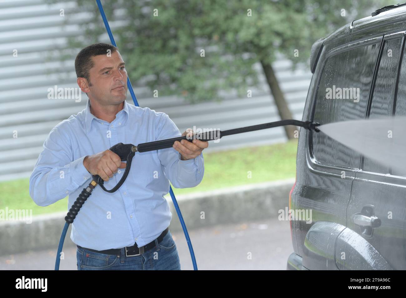 portrait of man pressure washing vehicle Stock Photo - Alamy