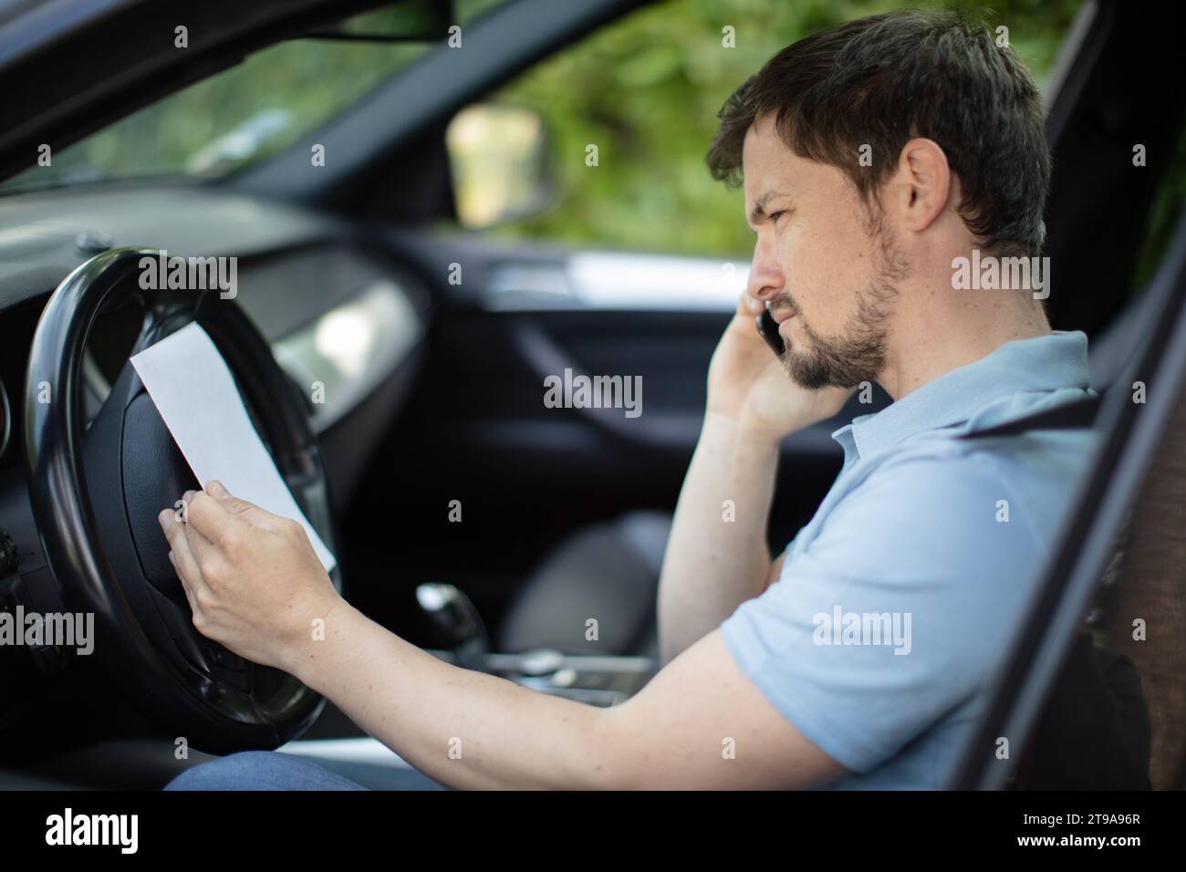 driver on the phone filing a paper form Stock Photo - Alamy