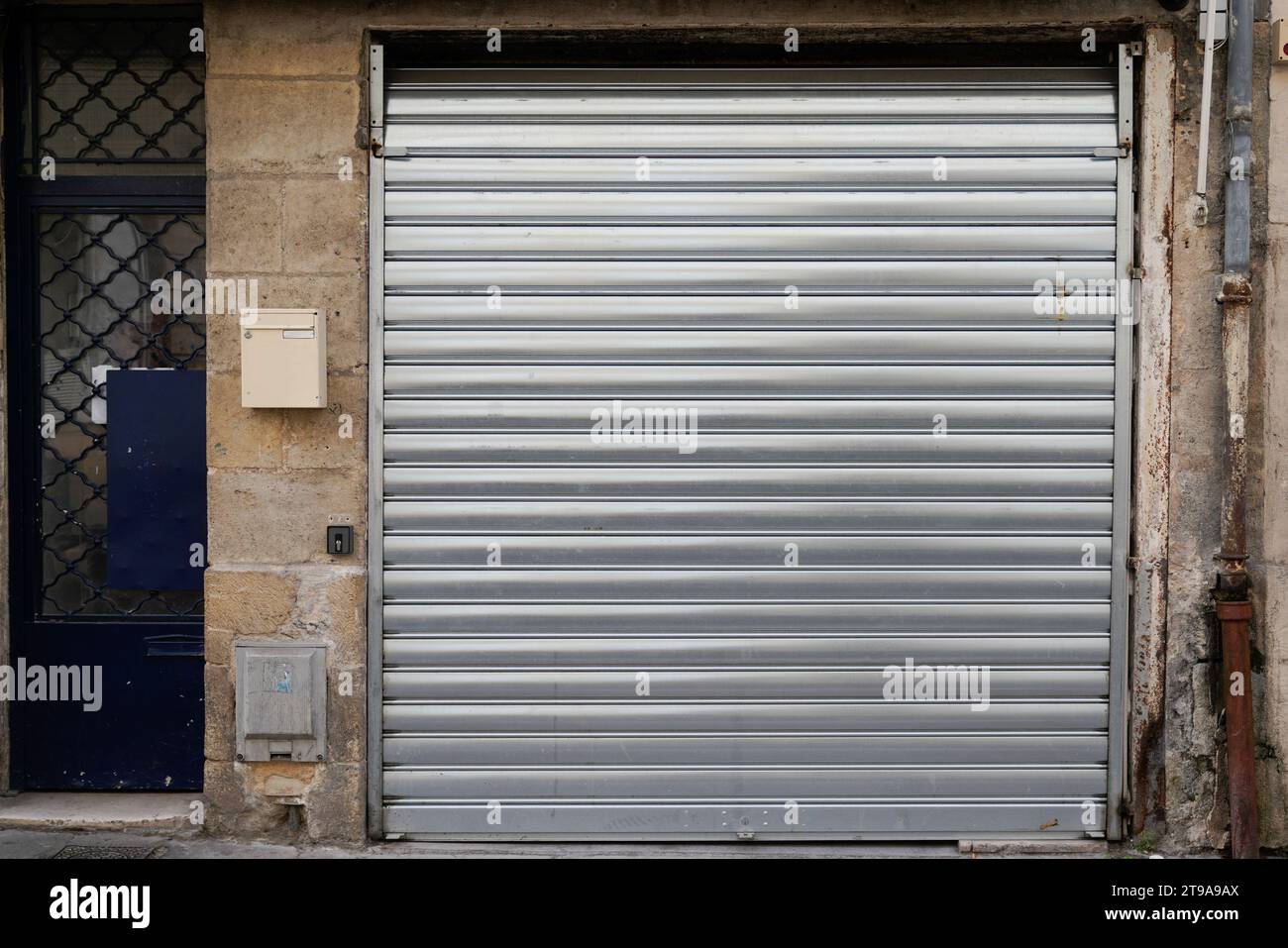 Old store facade ancient storefront with metallic closed curtains in ...