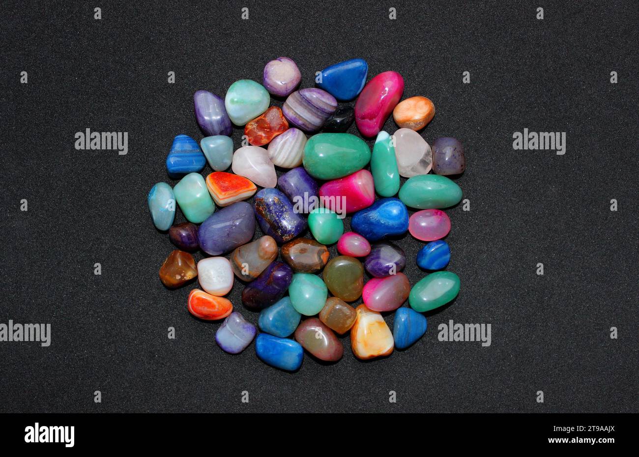 Bunch of processed and polished semi-precious quartz stones on a black ...