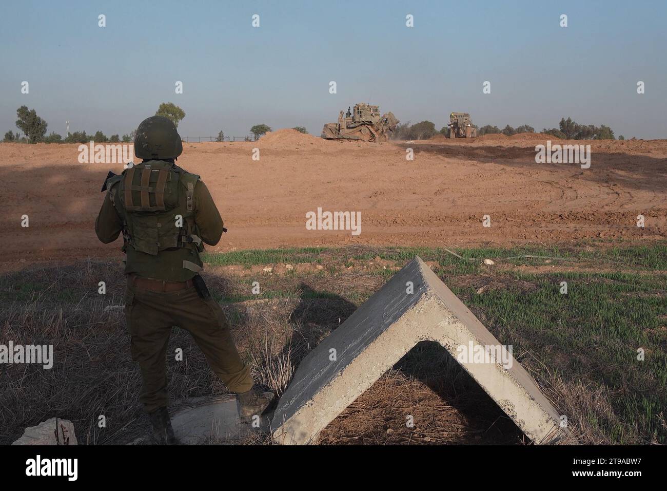 An Israeli soldier stands guard as D9 armored military bulldozers work ...
